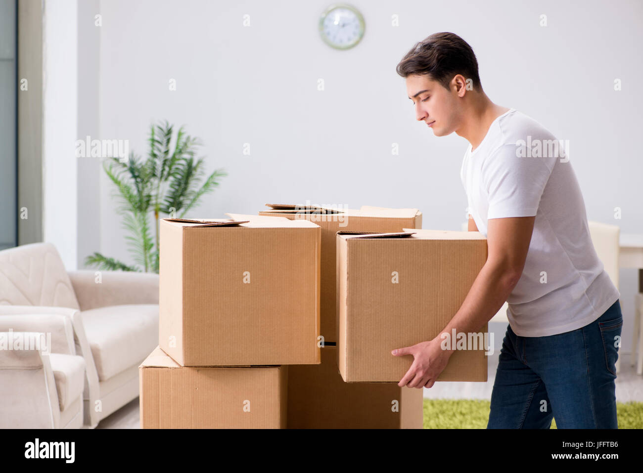 Young man moving boxes at home Stock Photo - Alamy