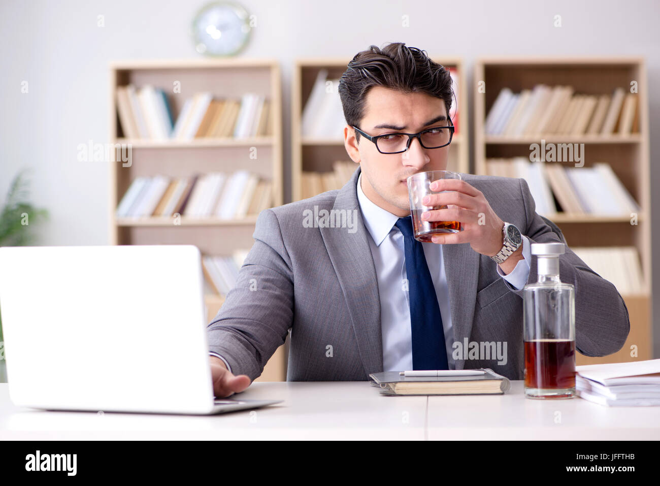 Young businessman drinking from stress Stock Photo - Alamy