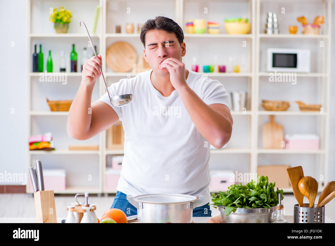 Young male cook working in the kitchen Stock Photo - Alamy