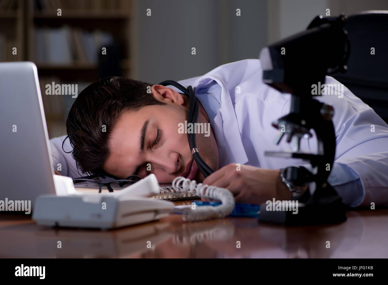 Young doctor working late in the office Stock Photo - Alamy