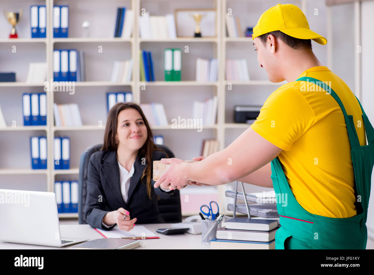 Postman delivering parcel to the office Stock Photo - Alamy