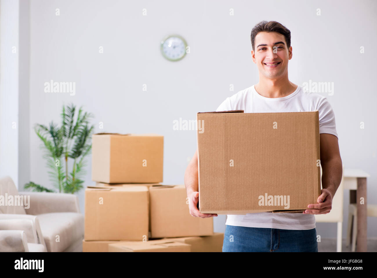 Young man moving boxes at home Stock Photo - Alamy