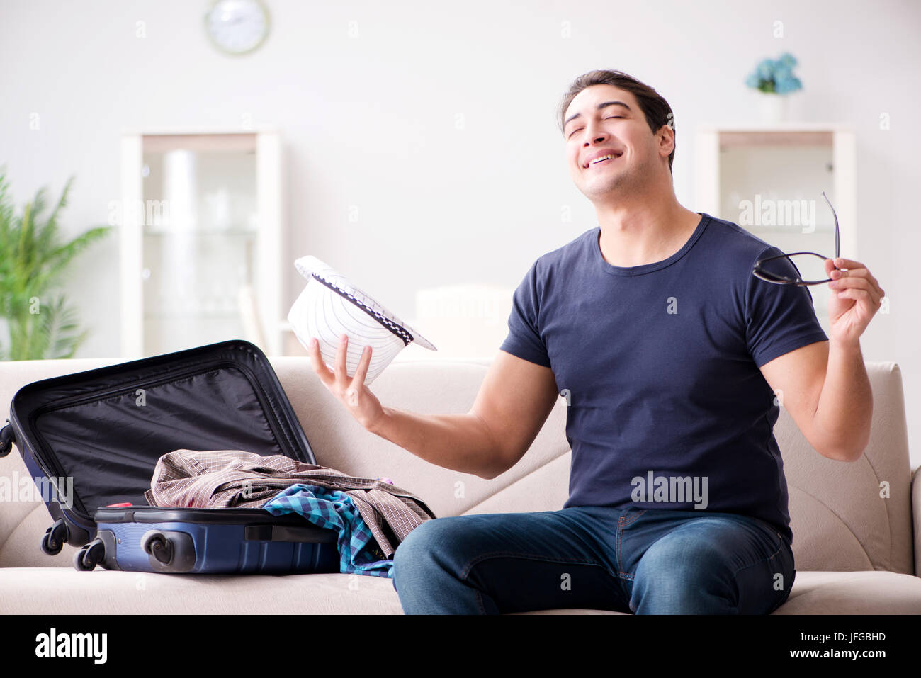 Man going on vacation packing his suitcase Stock Photo - Alamy