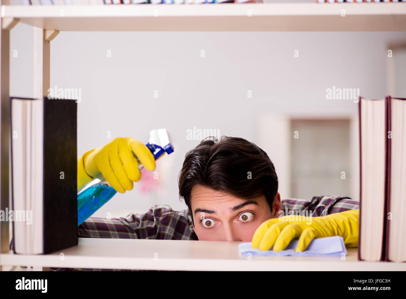 Man cleaning dust from bookshelf Stock Photo - Alamy