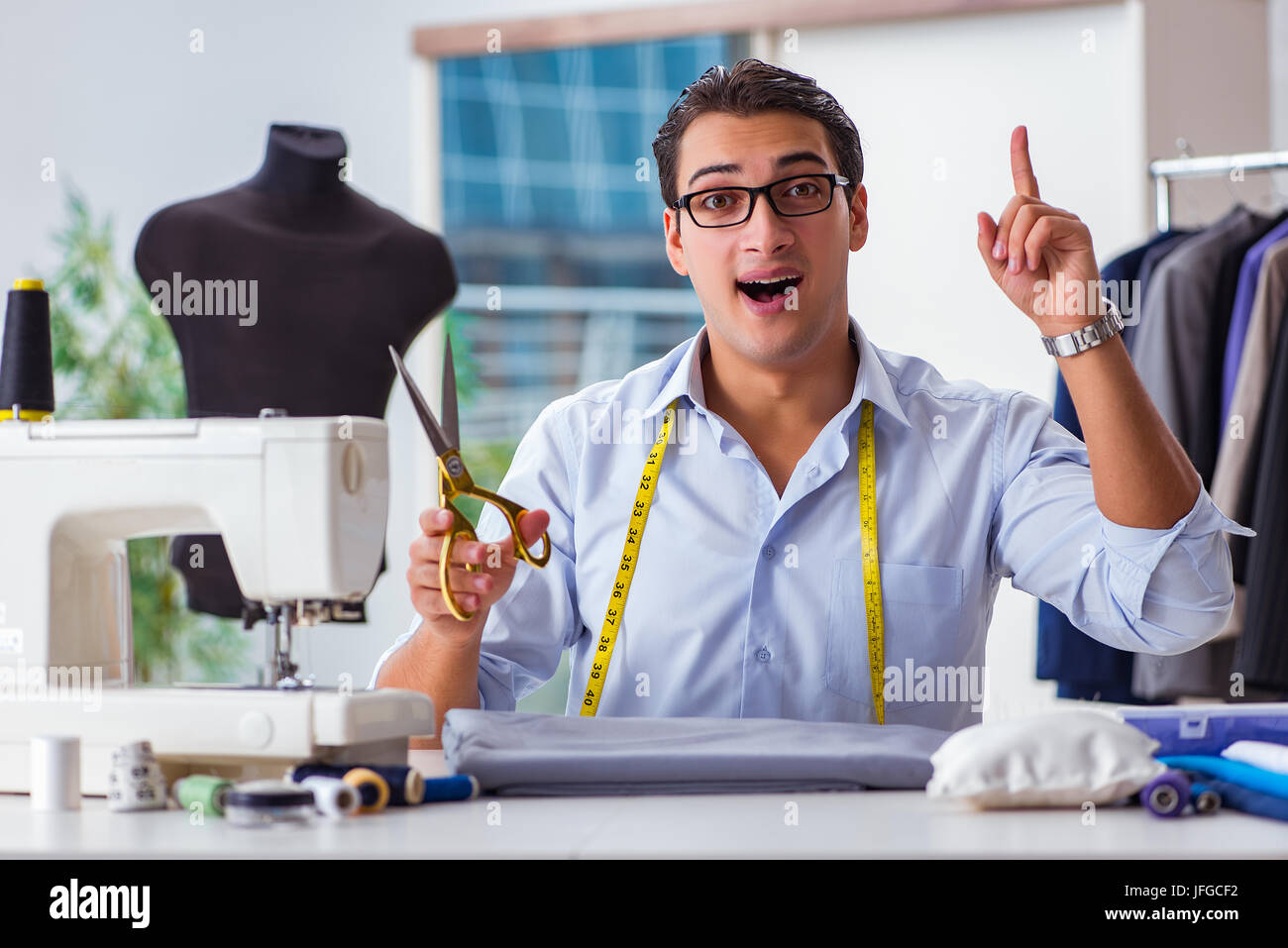 Young man tailor working on new clothing Stock Photo - Alamy