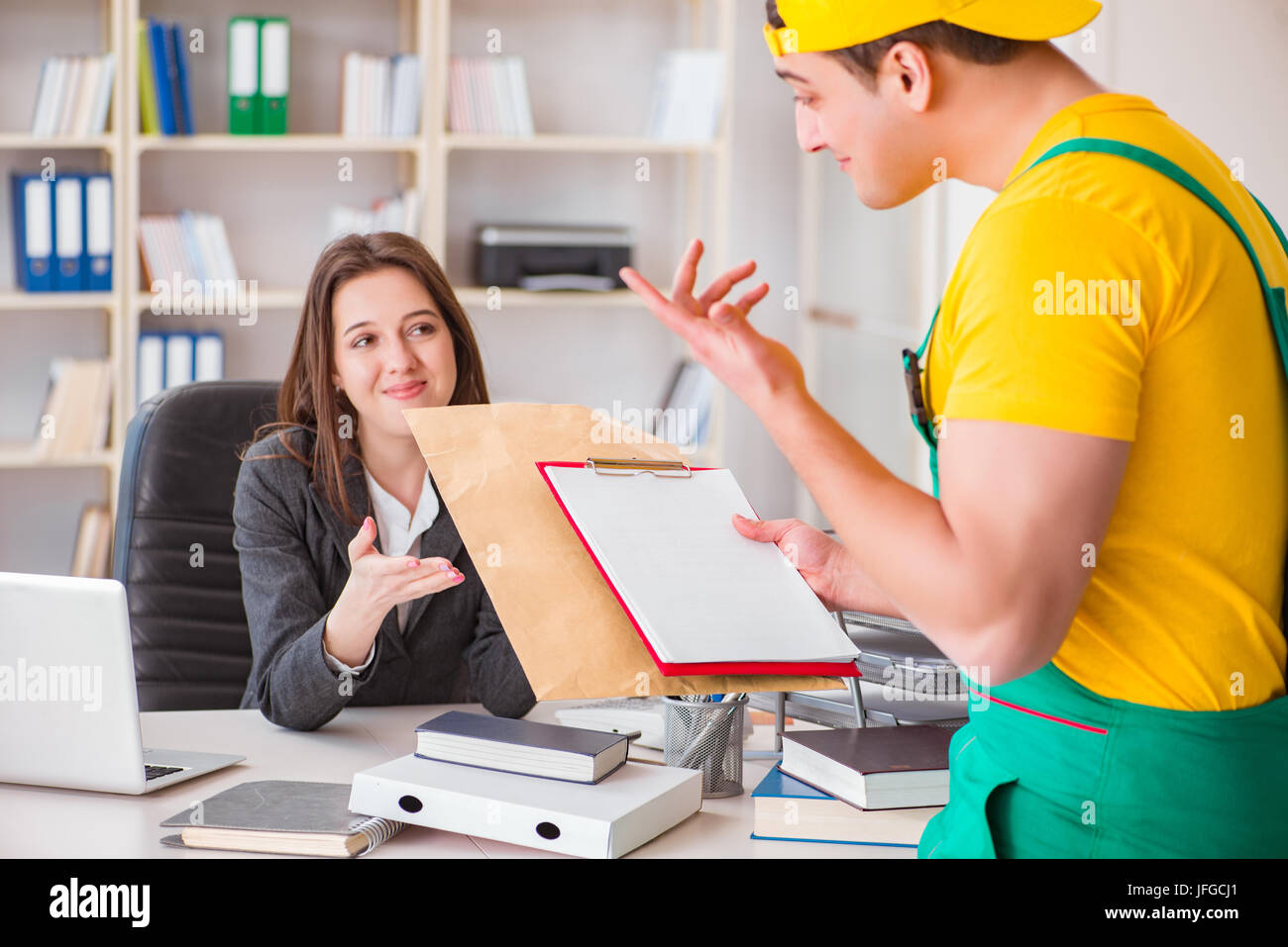 Postman delivering parcel to the office Stock Photo - Alamy