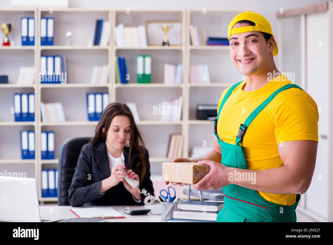 Postman delivering parcel to the office Stock Photo - Alamy