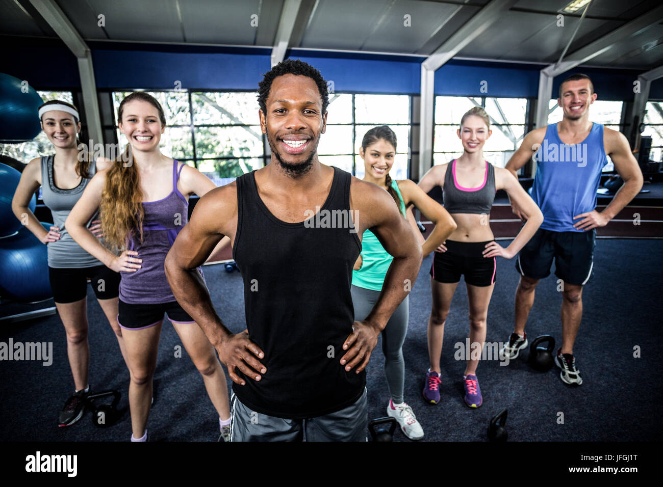 Smiling fitness class posing together with hands on hips Stock Photo ...