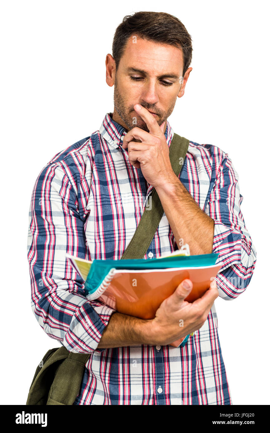 Thoughtful man standing while holding notepads Stock Photo - Alamy