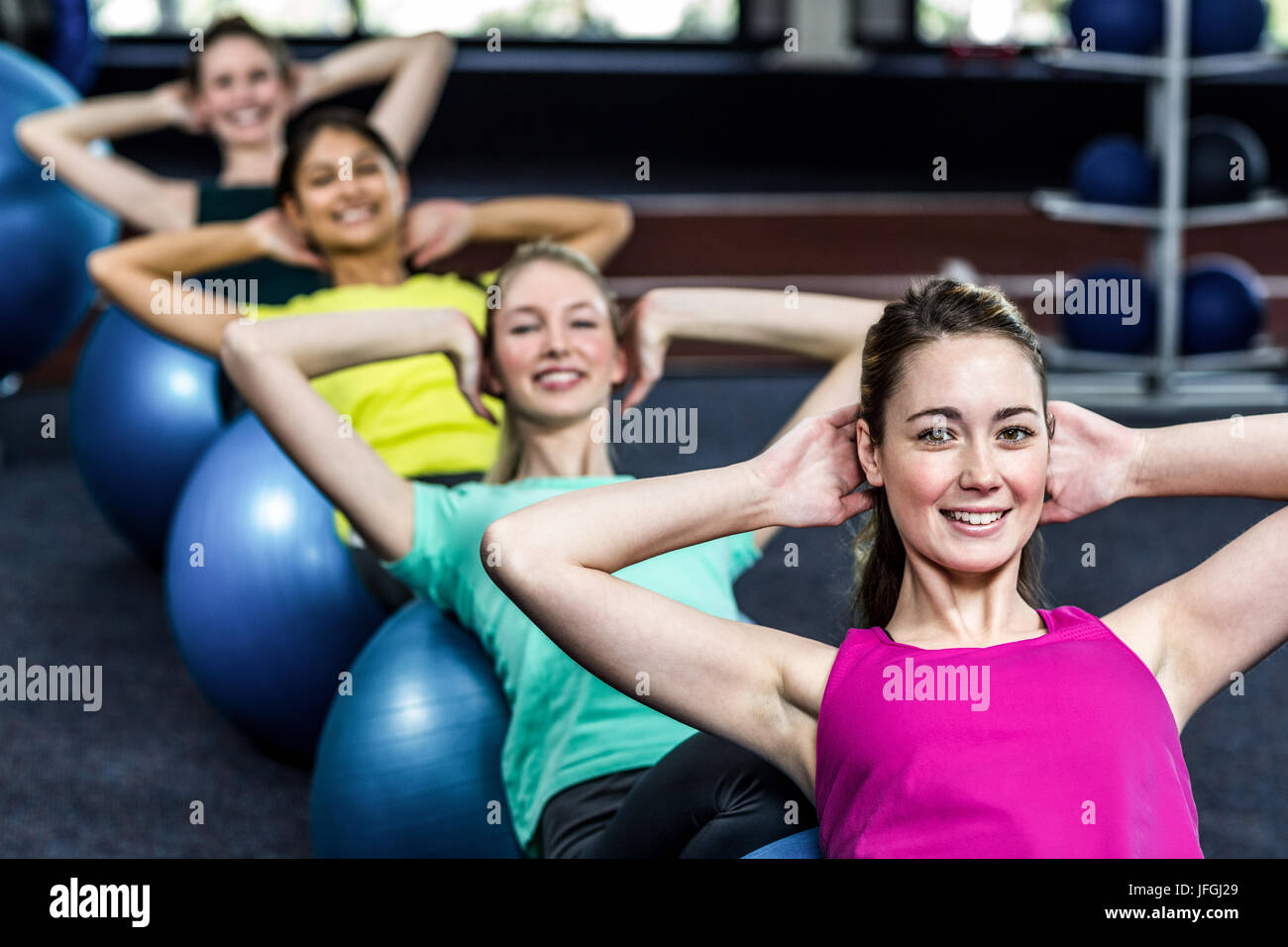 Fitness class doing sit ups on exercise balls Stock Photo - Alamy
