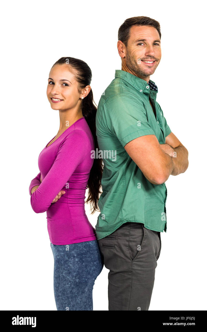 Couple standing back to back and smiling at the camera Stock Photo - Alamy