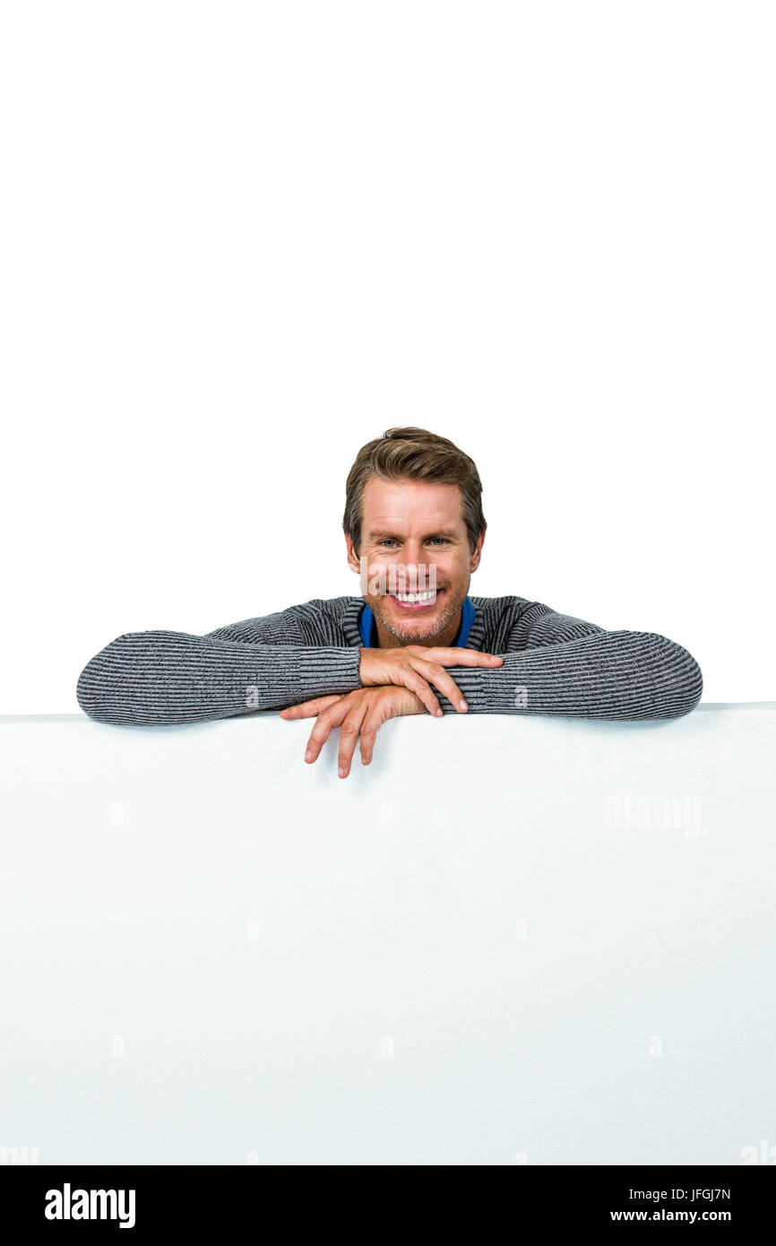 Smiling man on table against white background Stock Photo - Alamy