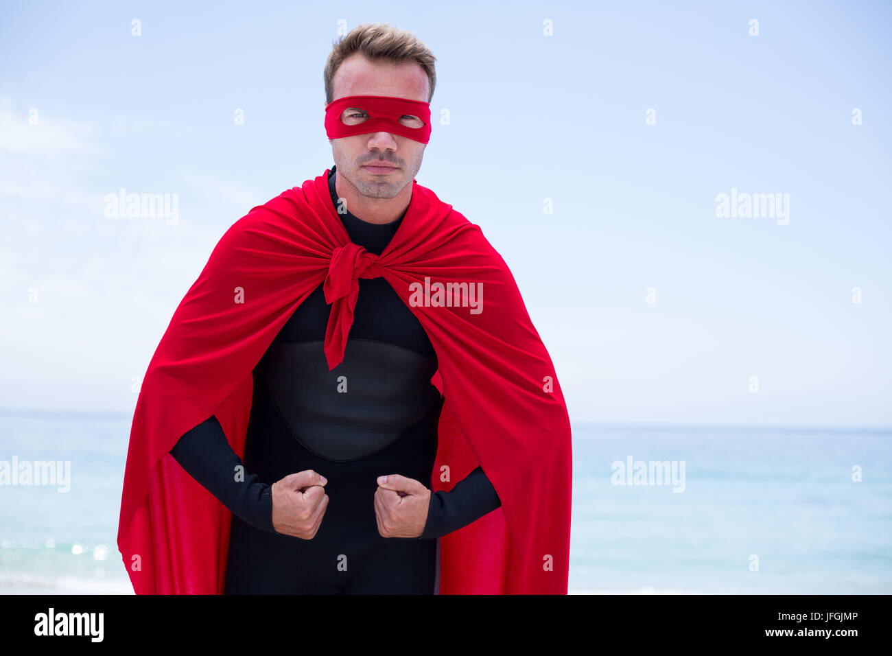 Serious man in superhero costume standing at sea shore Stock Photo - Alamy