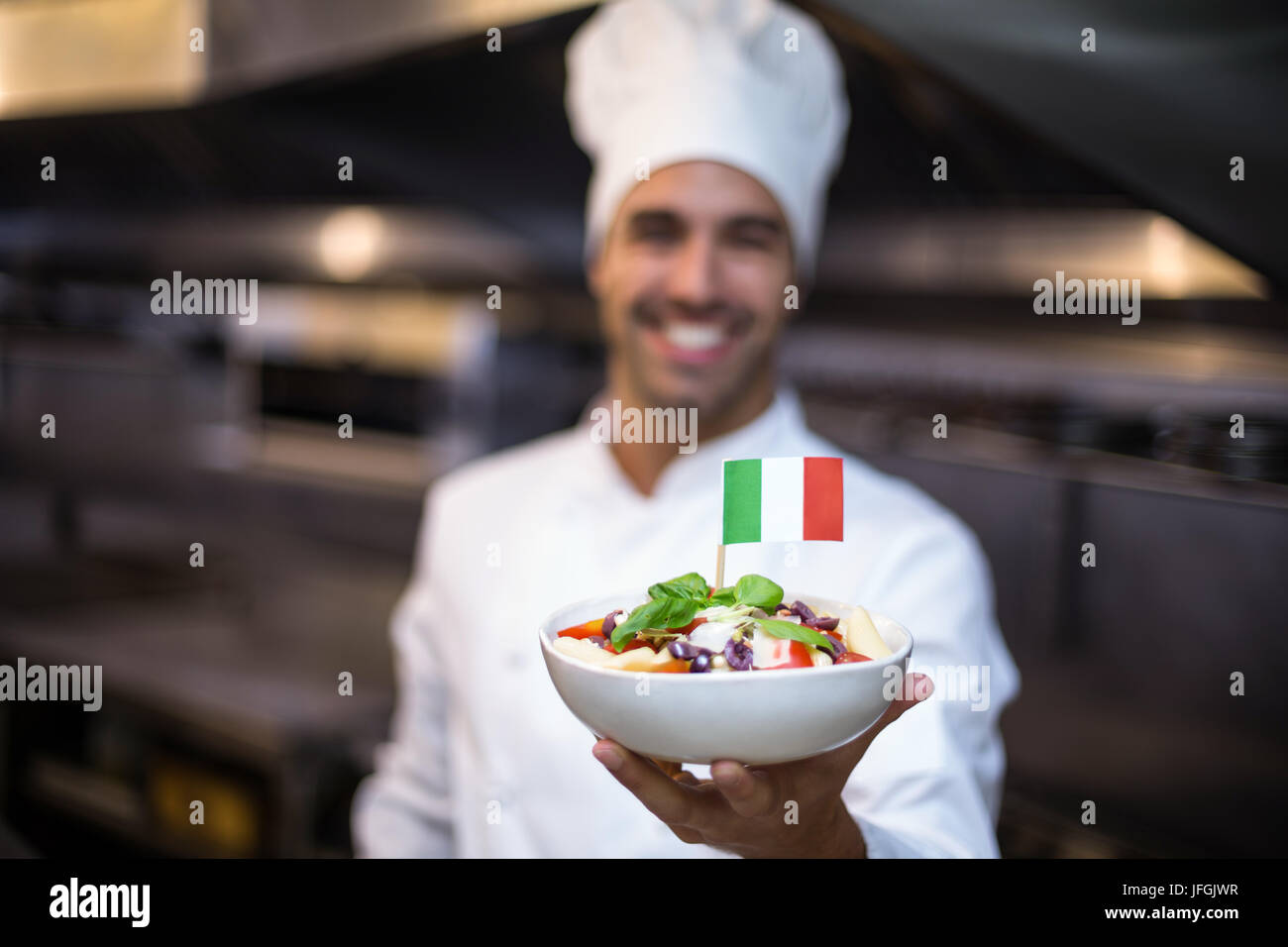 Handsome chef presenting meal with italian flag Stock Photo - Alamy