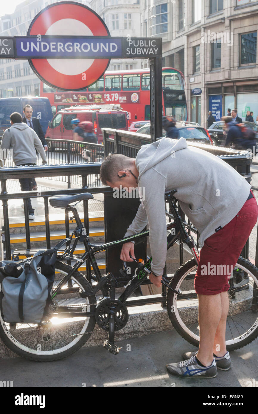Cyclist attaching bicycle to railings hi-res stock photography and ...