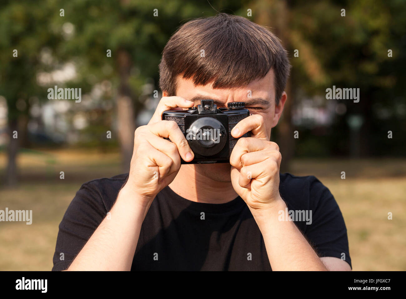 Young man takes a photo with an old camera Stock Photo - Alamy