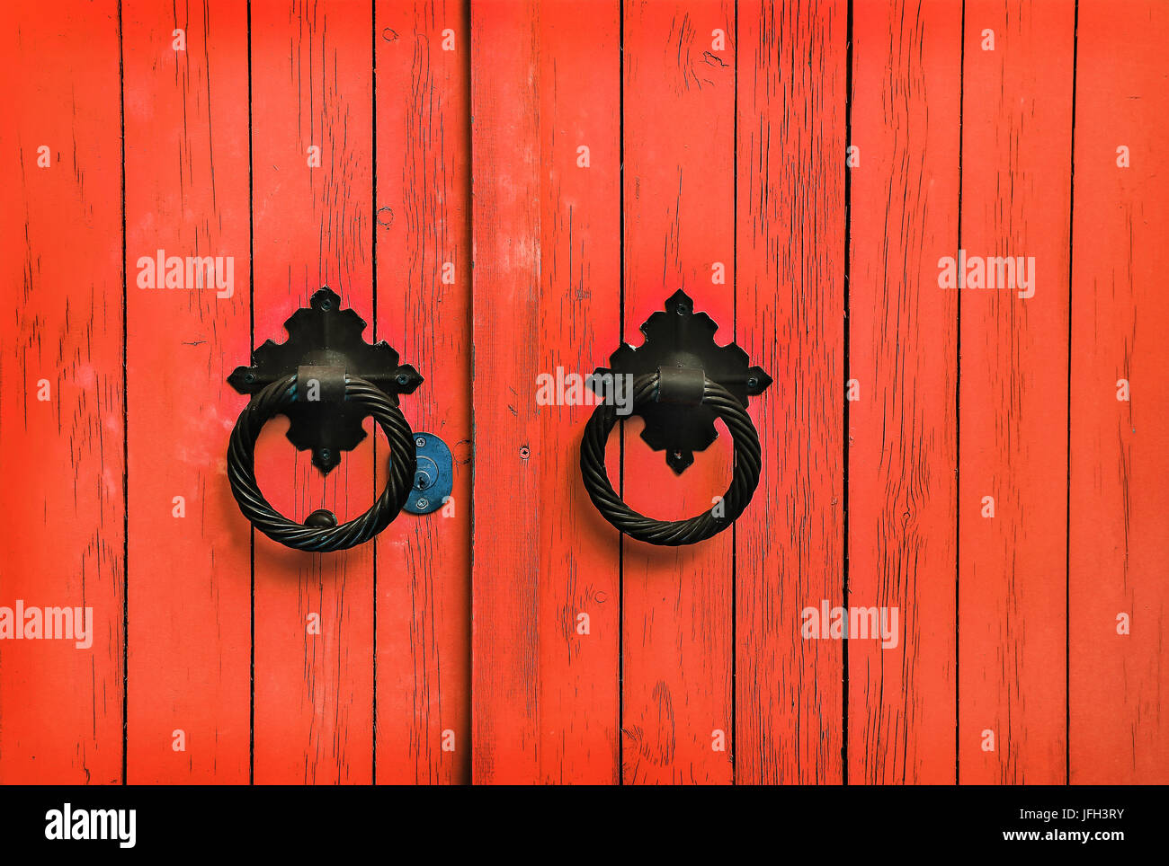 Red wooden door with round handles Stock Photo - Alamy