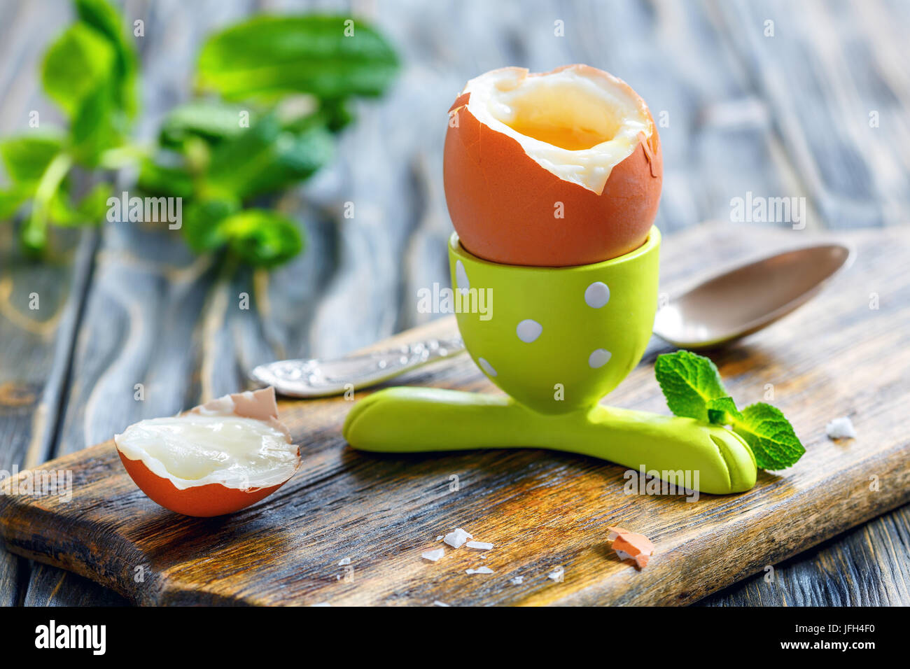 The soft-boiled egg in a funny green stand Stock Photo - Alamy