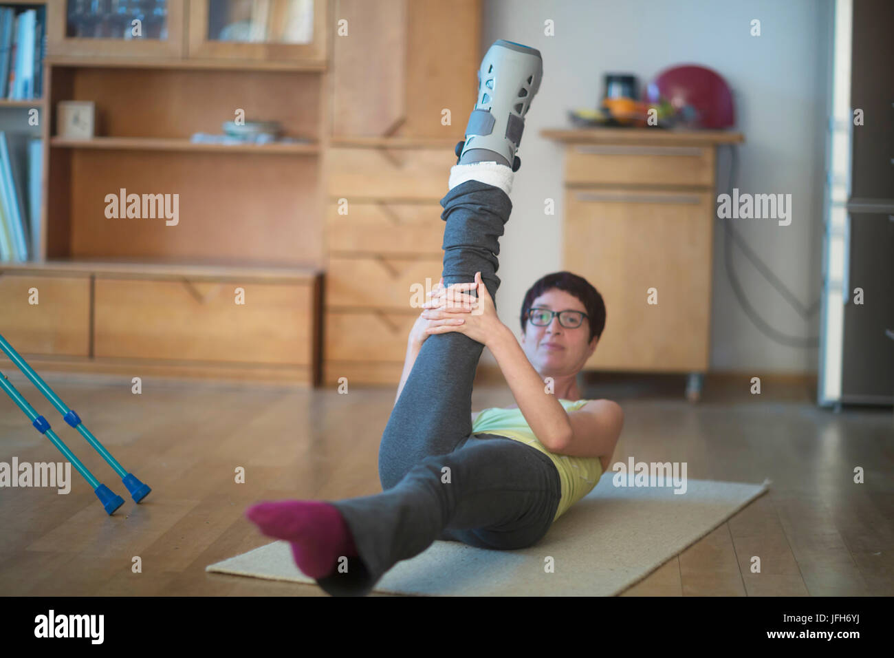 Woman doing stretch exercise with a broken leg Stock Photo - Alamy