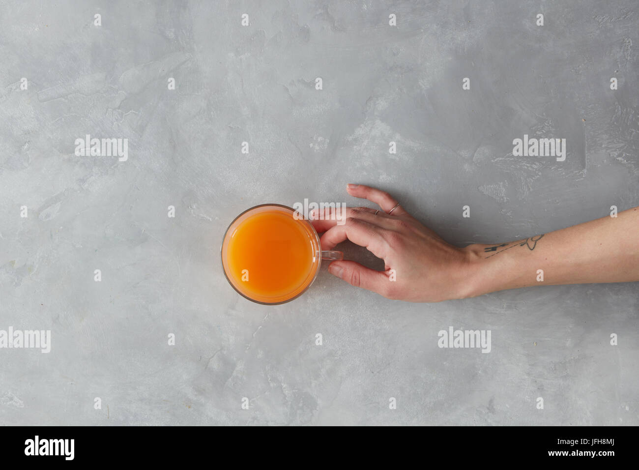 Hand holding orange juice glass hi-res stock photography and images - Alamy