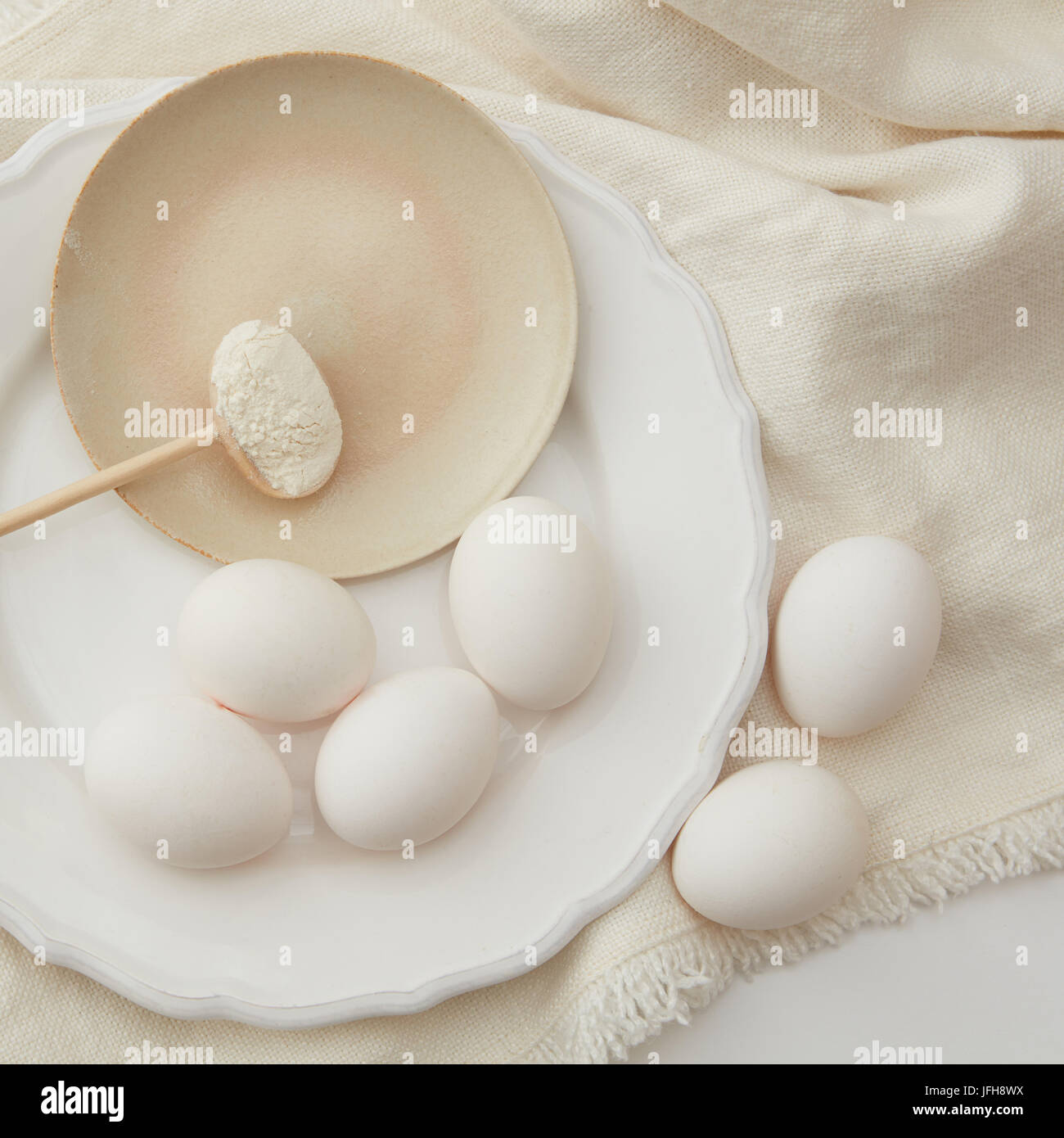 Raw eggs and spoon of flour Stock Photo - Alamy