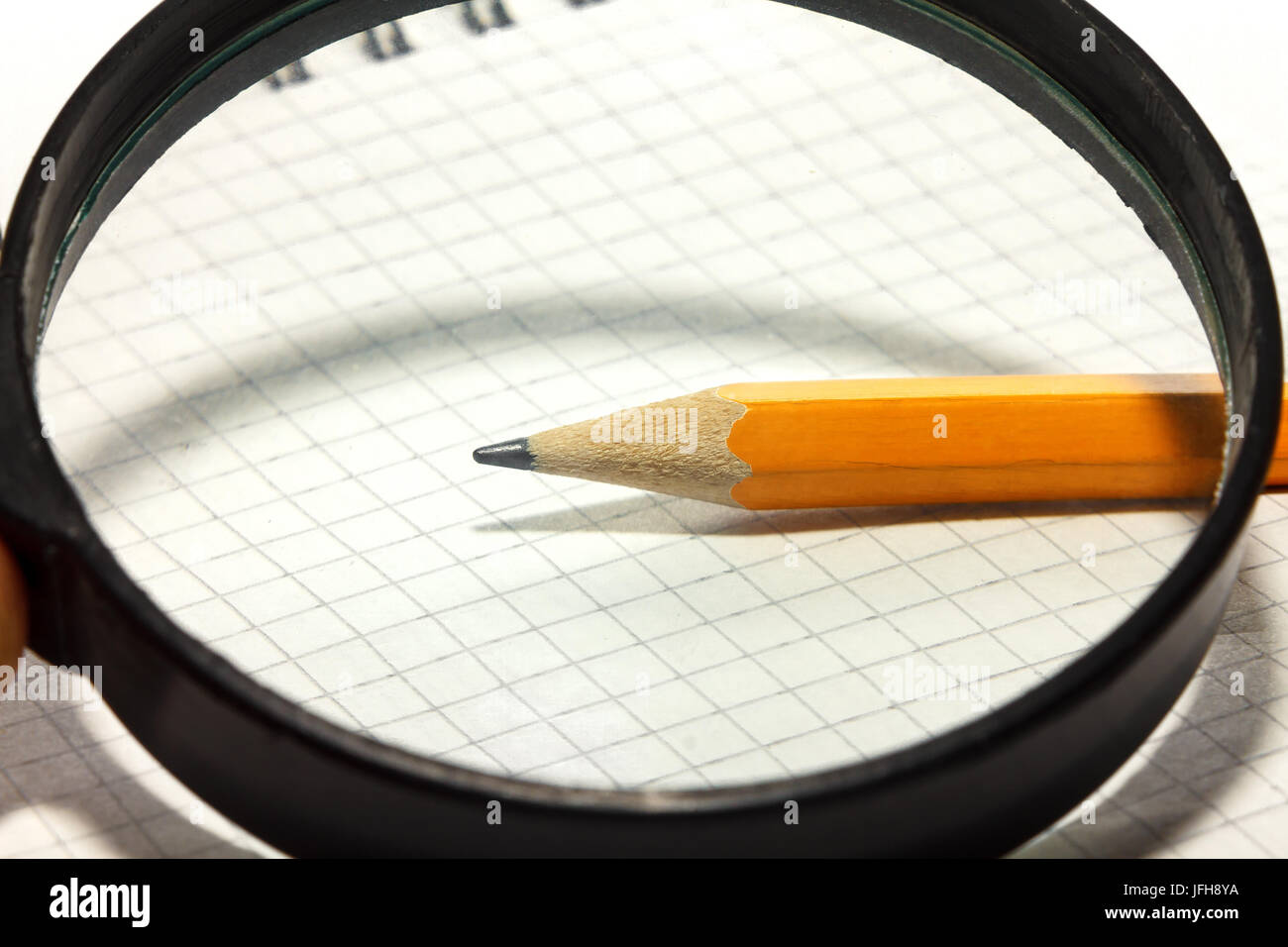 Pencil and magnifier on a notebook Stock Photo - Alamy