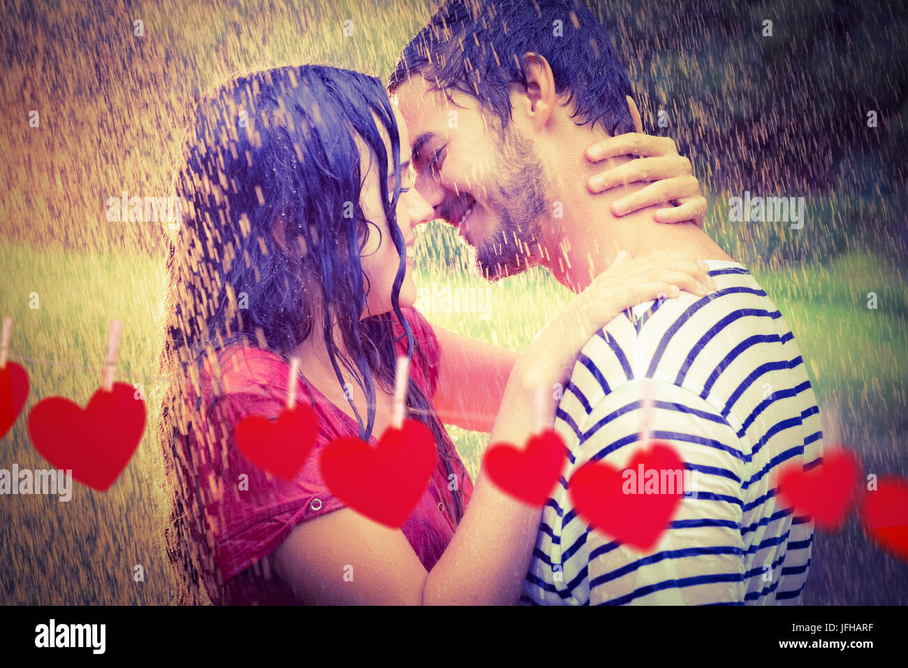 Composite image of cute couple hugging under the rain Stock Photo - Alamy