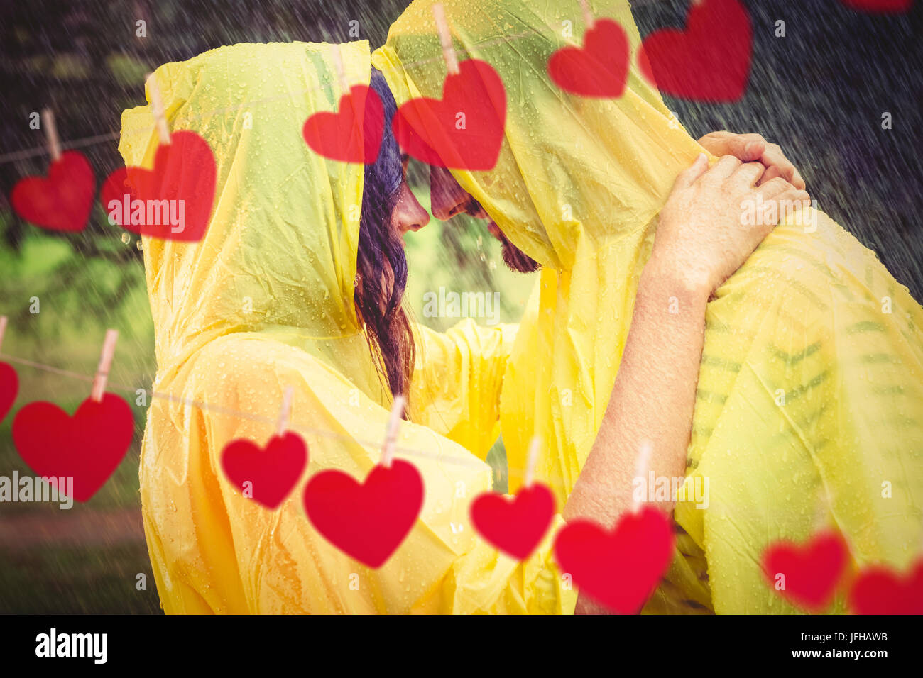 Composite image of couple hugging in the rain Stock Photo - Alamy