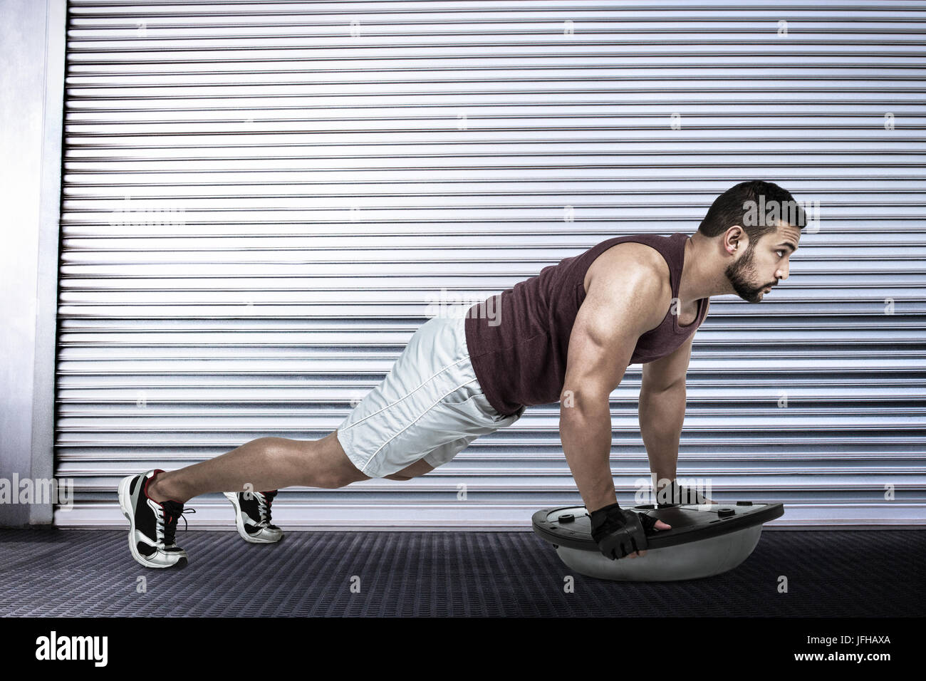 Composite image of muscular man doing bosu push ups Stock Photo - Alamy