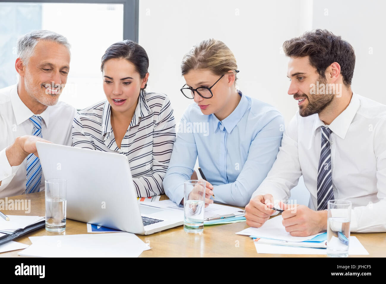 Business colleagues discussing office work on laptop Stock Photo - Alamy