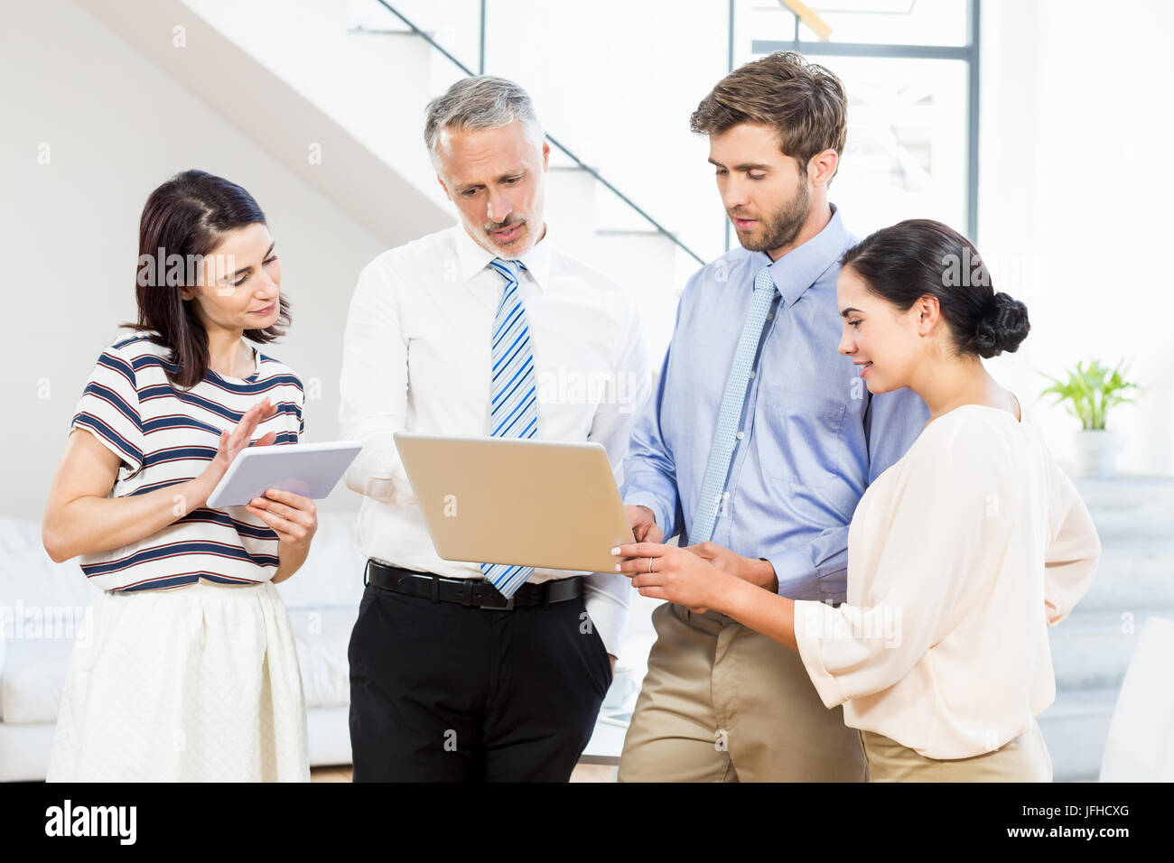 Business people interacting using digital tablet and laptop Stock Photo ... Business people interacting using digital tablet and laptop Stock Photo ...