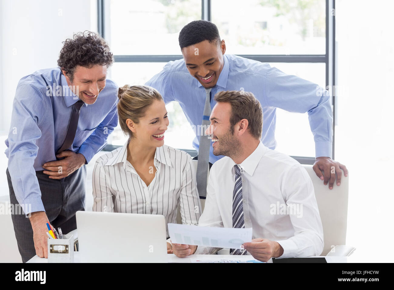 Happy business colleagues reviewing a report at desk Stock Photo - Alamy