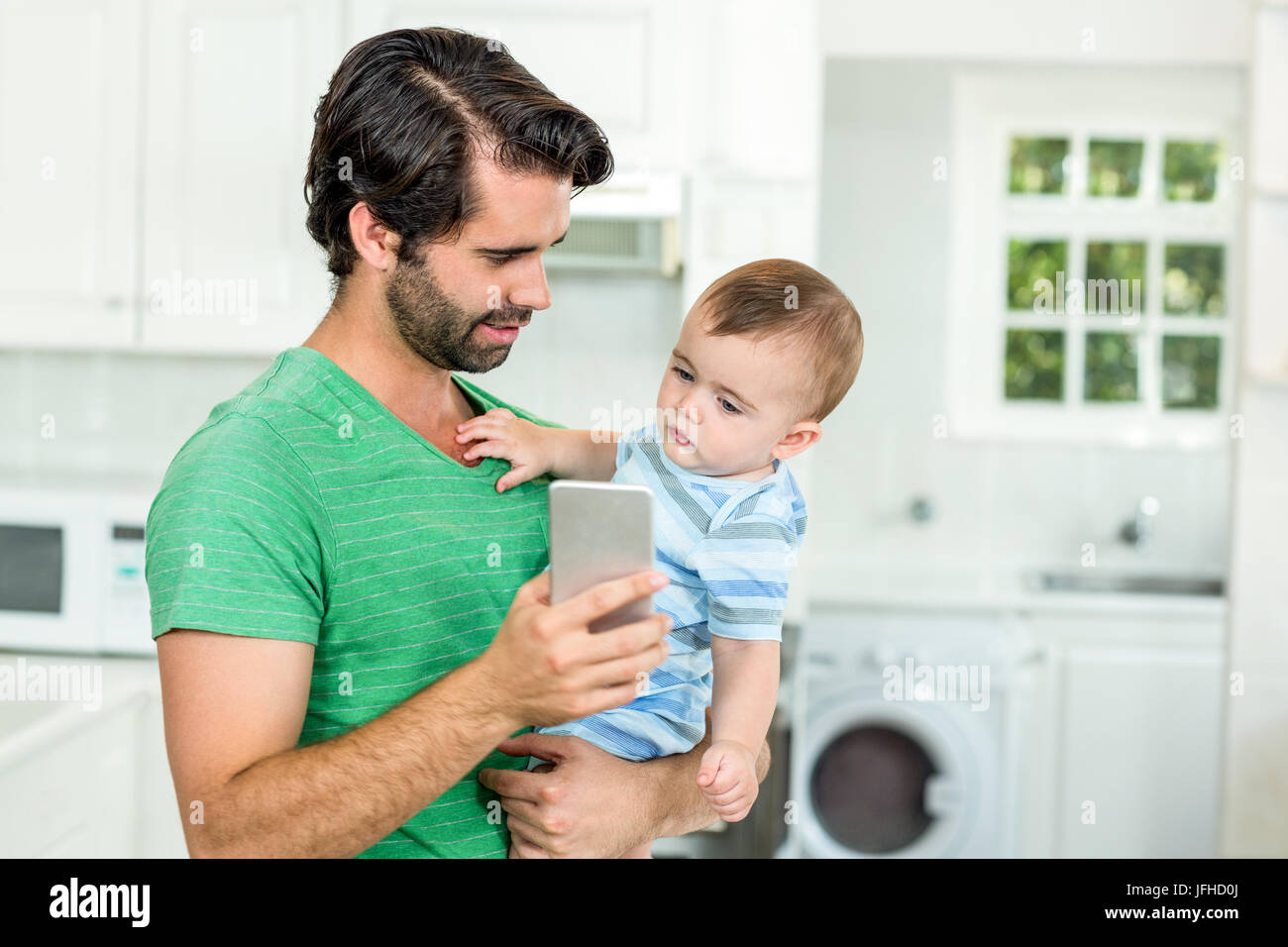 Father showing mobile phone to cute baby boy Stock Photo - Alamy