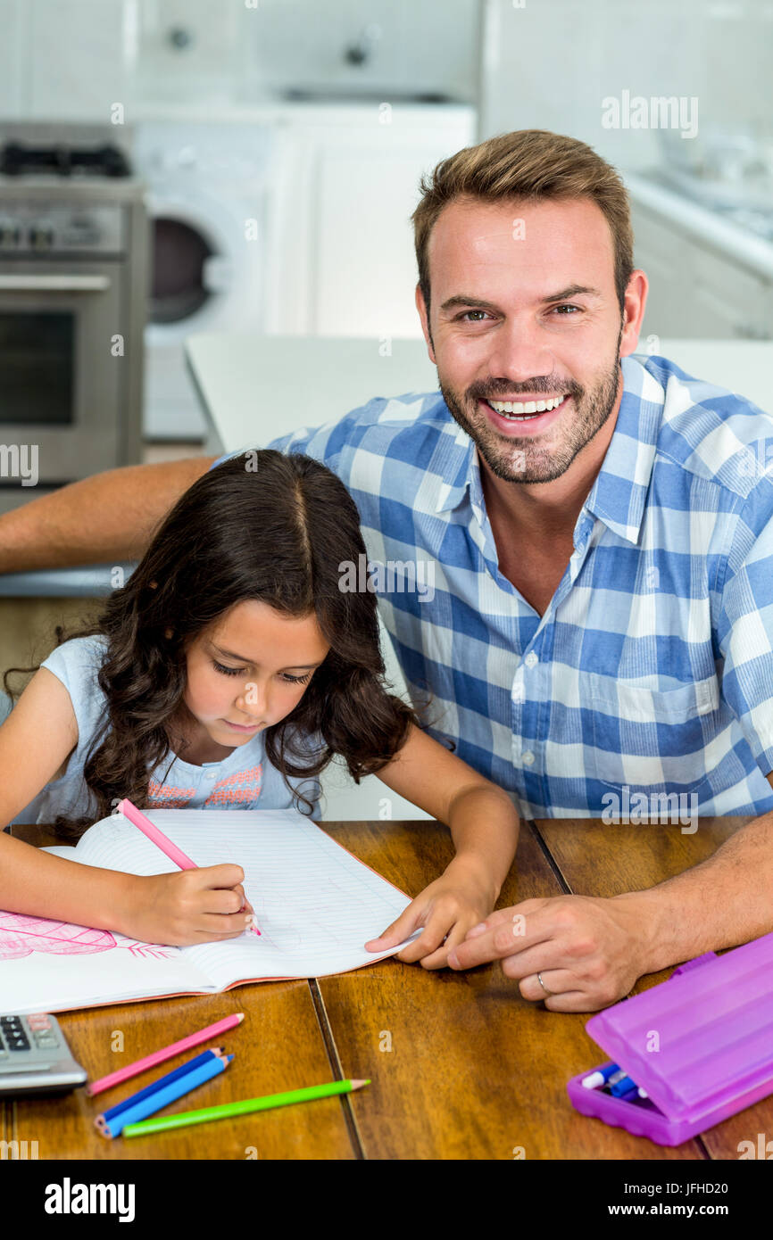 Happy father with daughter writing in book at home Stock Photo - Alamy
