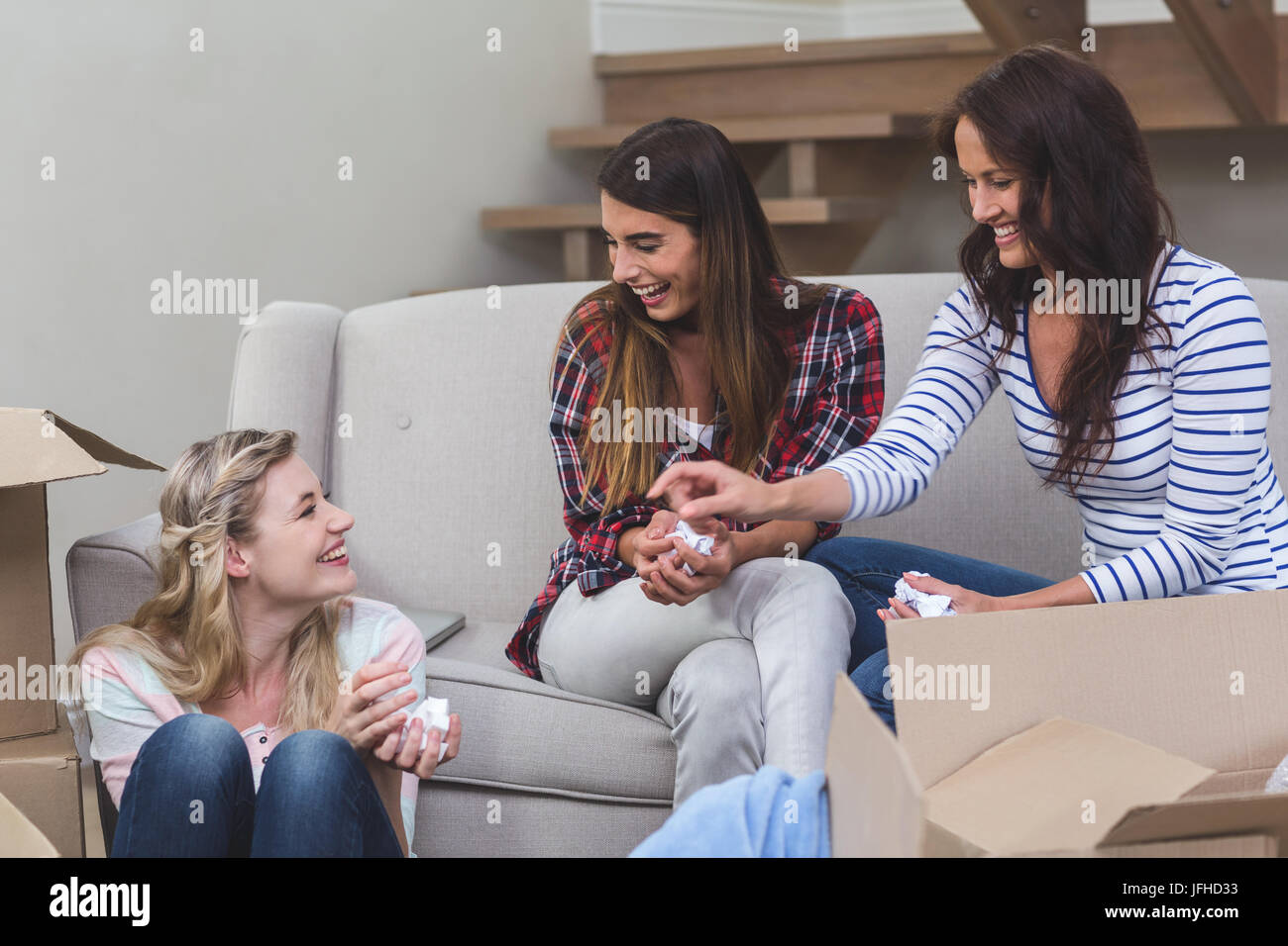 Friends interacting with each other in their new house Stock Photo - Alamy