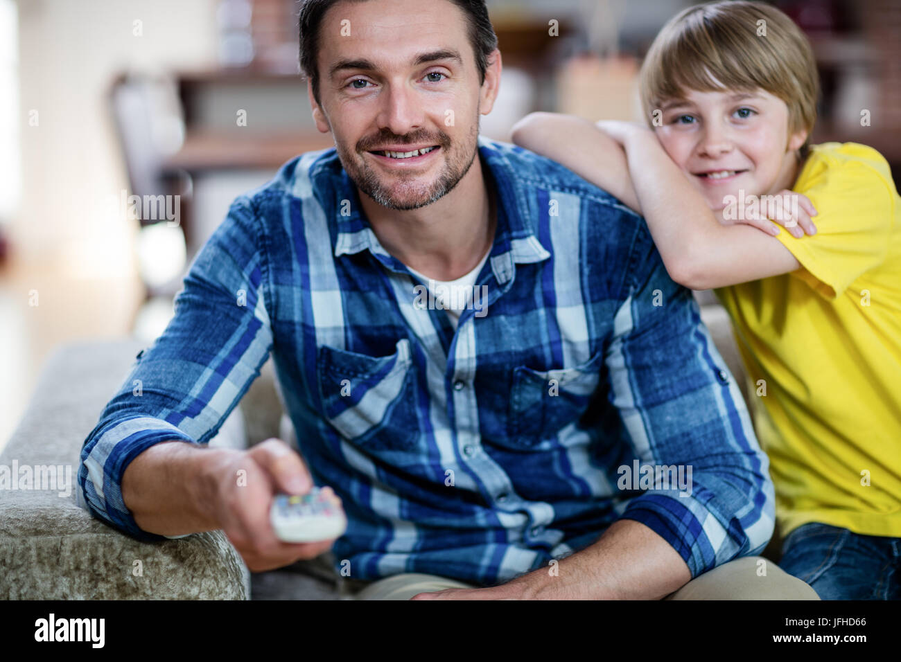 Father and son watching television in living room Stock Photo - Alamy