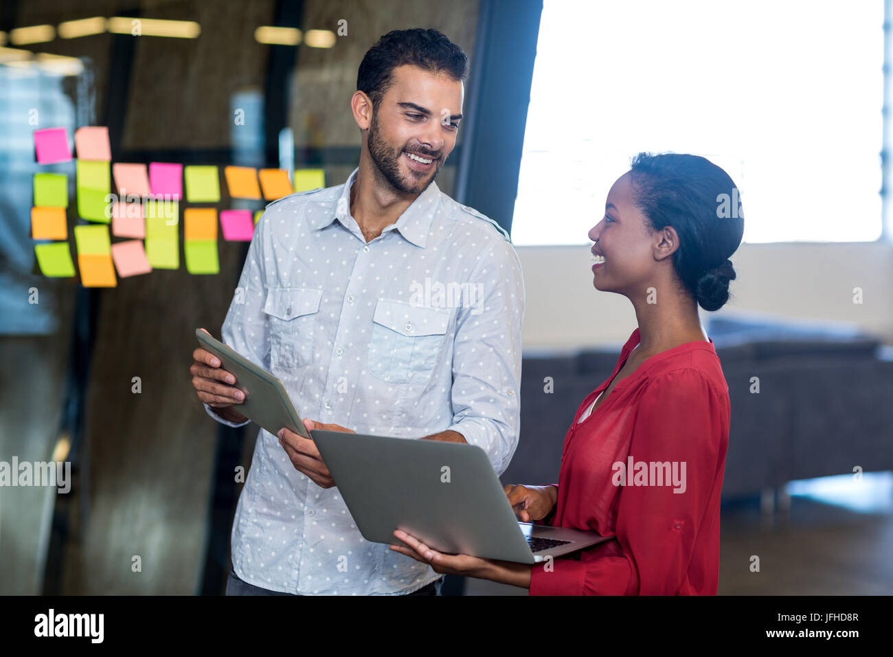 Colleagues interacting using digital tablet and laptop Stock Photo - Alamy