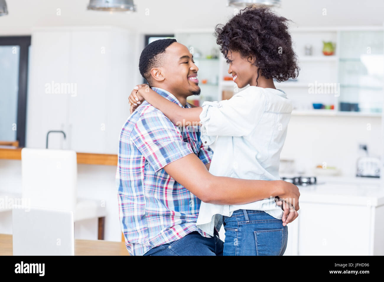 Young couple embracing face to face in kitchen Stock Photo - Alamy