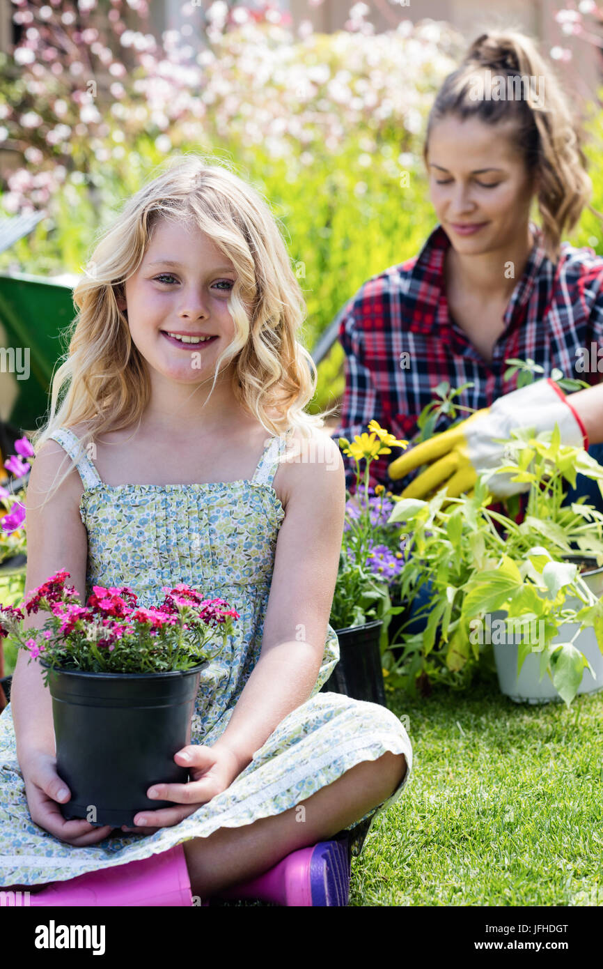 Portrait of girl sitting in garden with flower pot Stock Photo - Alamy