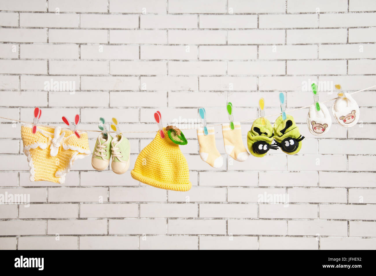 Children's clothes hanging on a rope against a white brick wall Stock ...