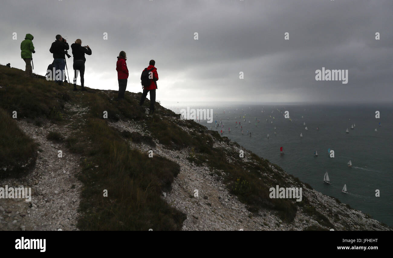 People take photos from the cliff tops as they watch hundreds of ...