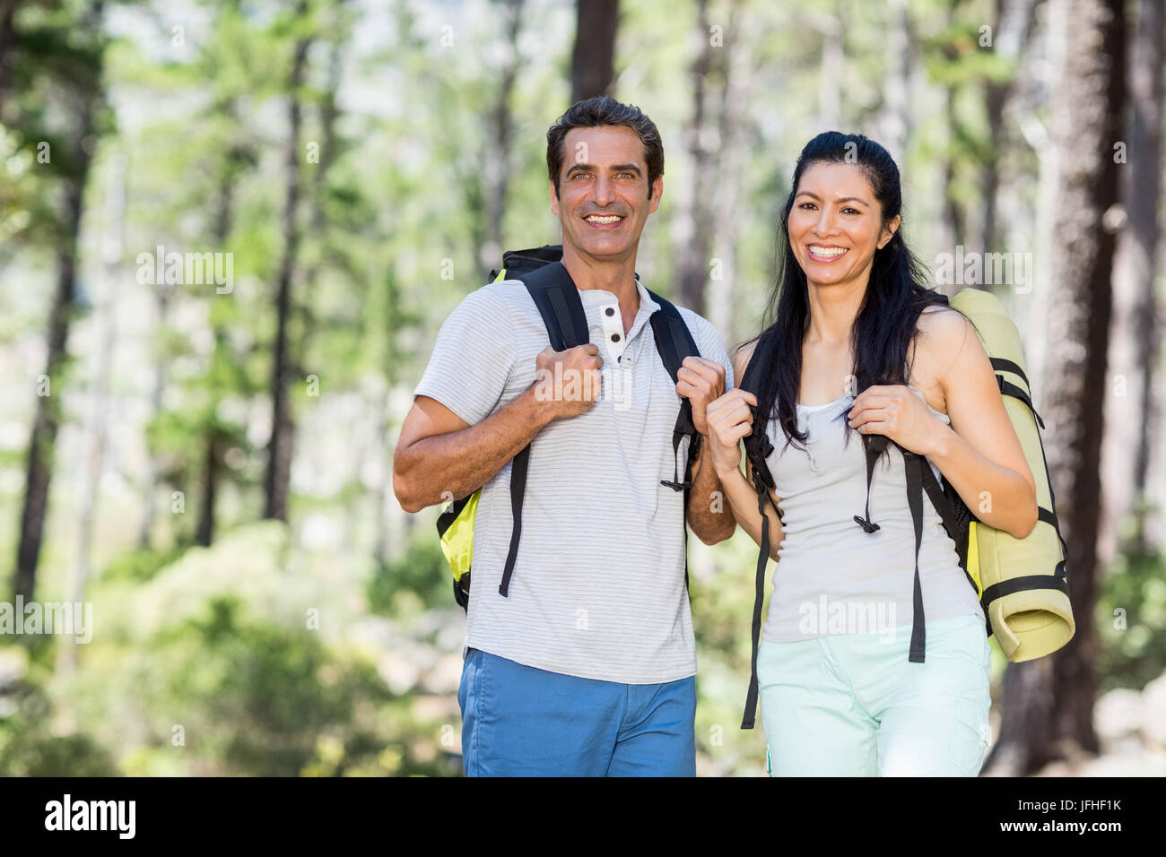 Couple smiling and posing with their backpack Stock Photo - Alamy