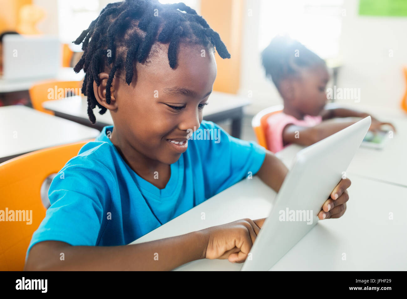 Side view of pupil using tablet pc in classroom Stock Photo - Alamy