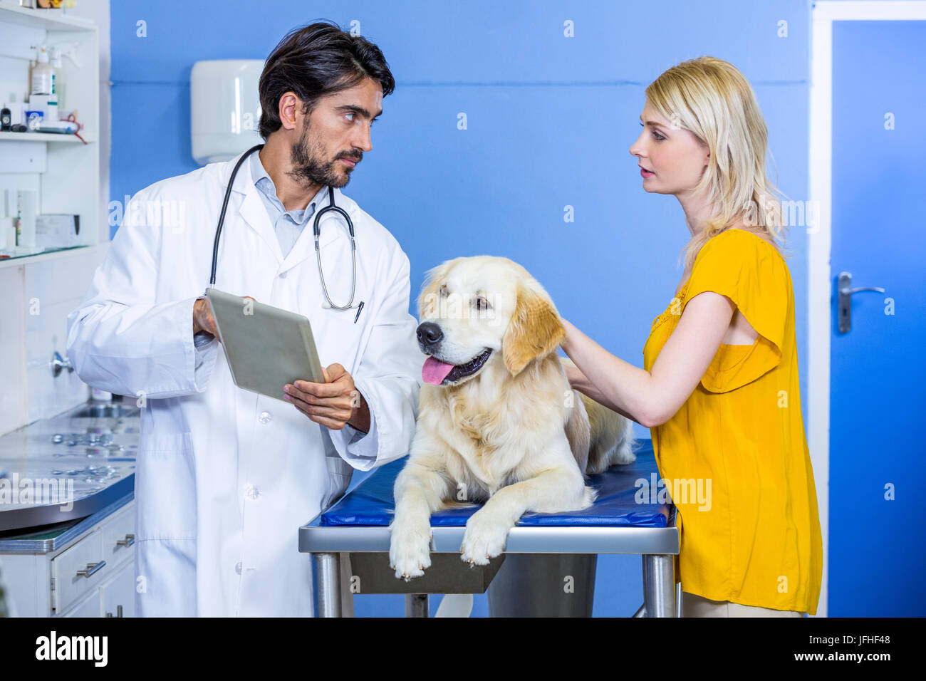 A man vet showing something with his tablet computer Stock Photo - Alamy