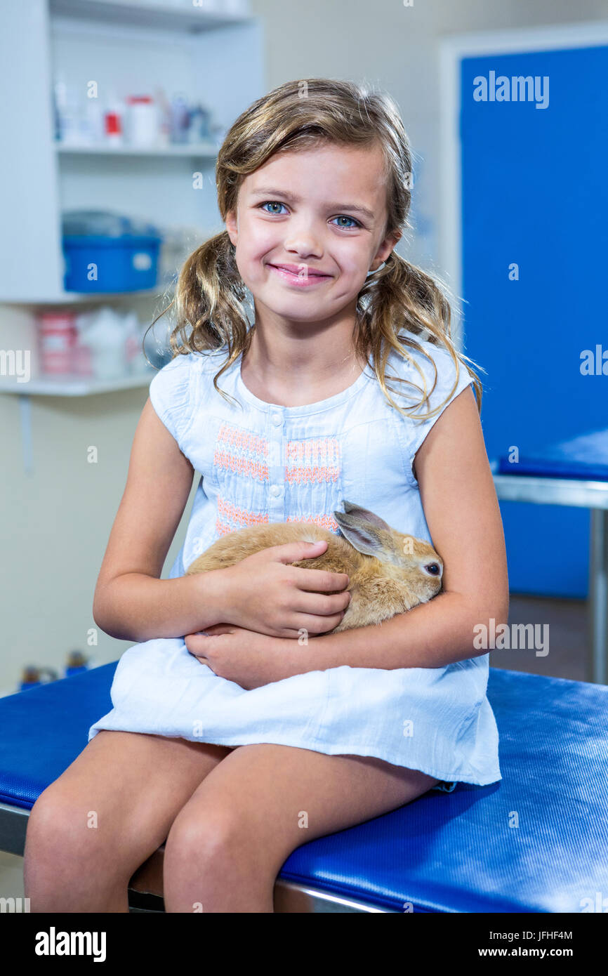 Cute girl holding her rabbit and looking at the camera Stock Photo - Alamy