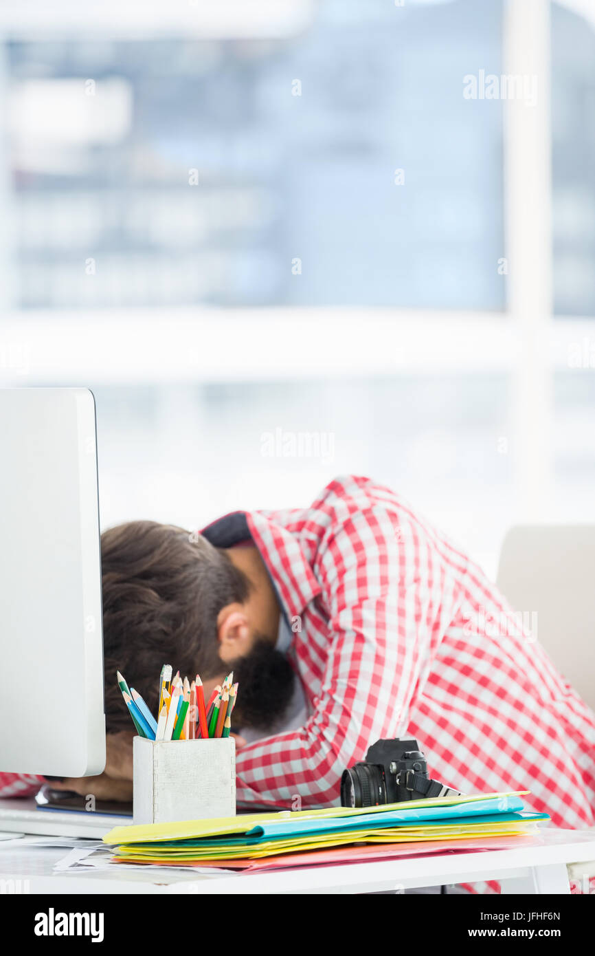 Hipster man sitting at computer desk is tired Stock Photo - Alamy