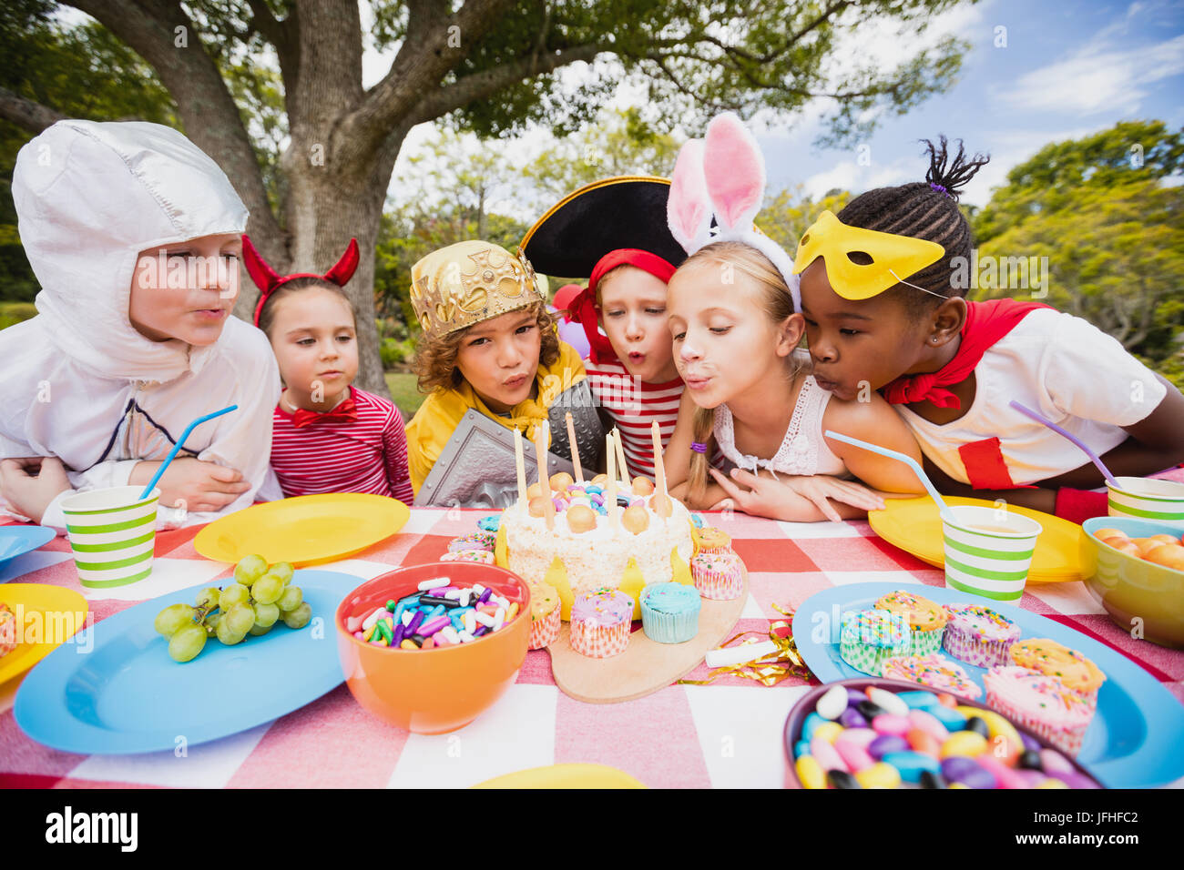 Cute children with fancy dress blowing on the candles together Stock ...