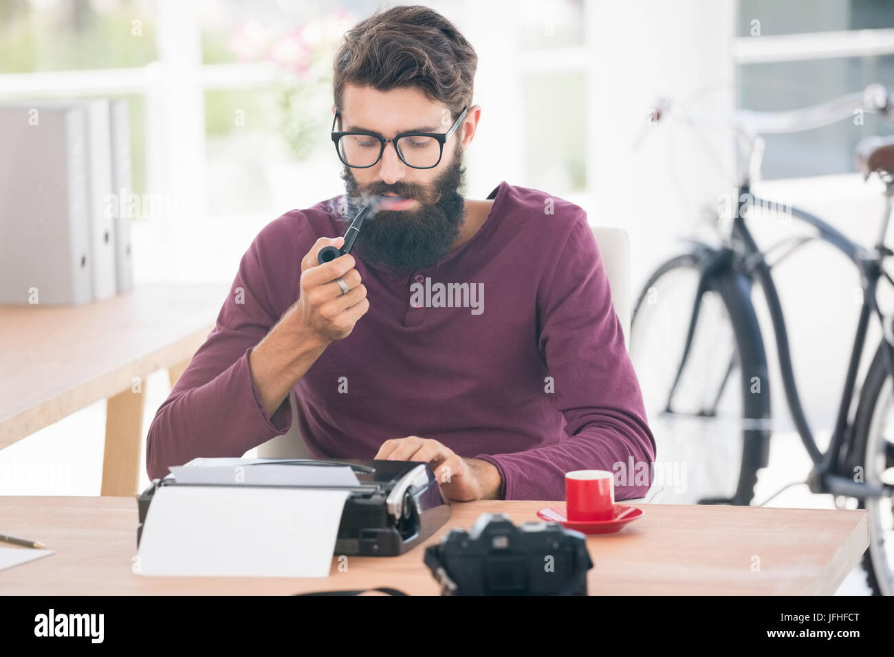 Hipster man using a typewriter and smoking the pipe Stock Photo - Alamy