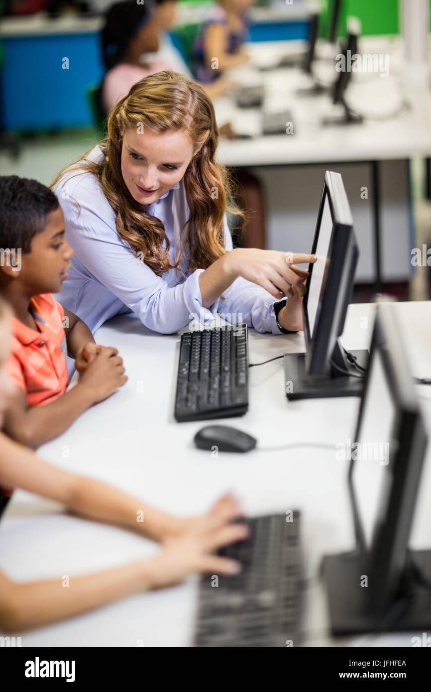 Teacher giving lesson to her students with technology Stock Photo - Alamy