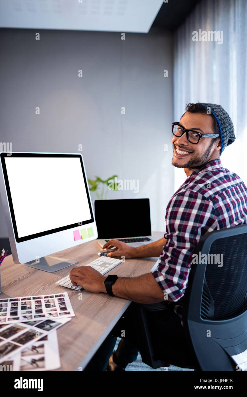 Portrait of casual man working at computer desk Stock Photo - Alamy